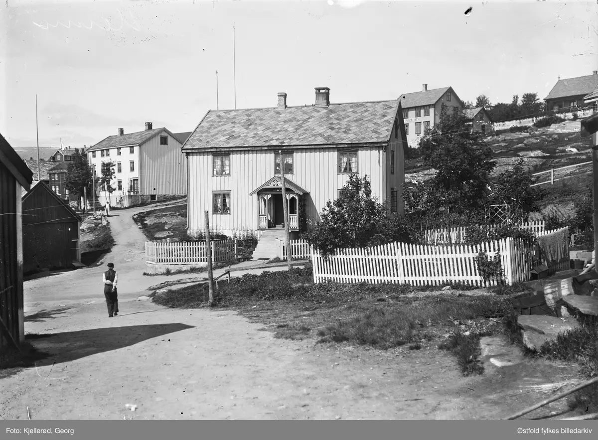 Gateparti i Hemnesberget i Nordland, i bakgrunnen hus med skilt ...