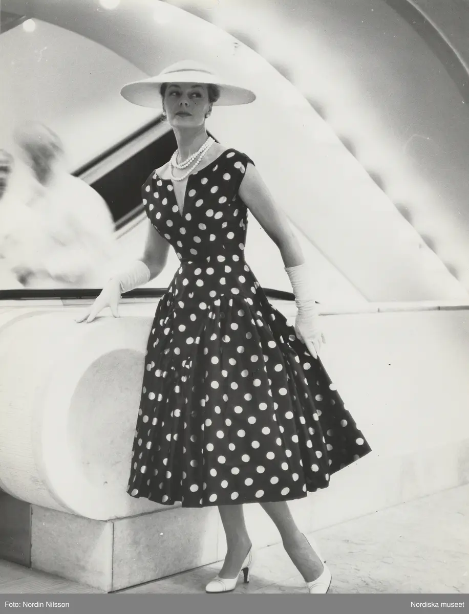Modell vid rulltrapporna på Nordiska Kompaniet. Klädd i prickig ...