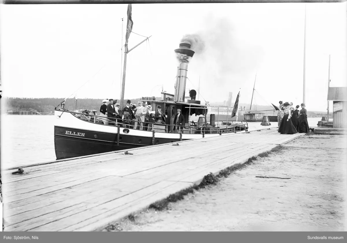 Ångaren Ellen vid kaj i Svartvik med ett uppsluppet sällskap på däck ...