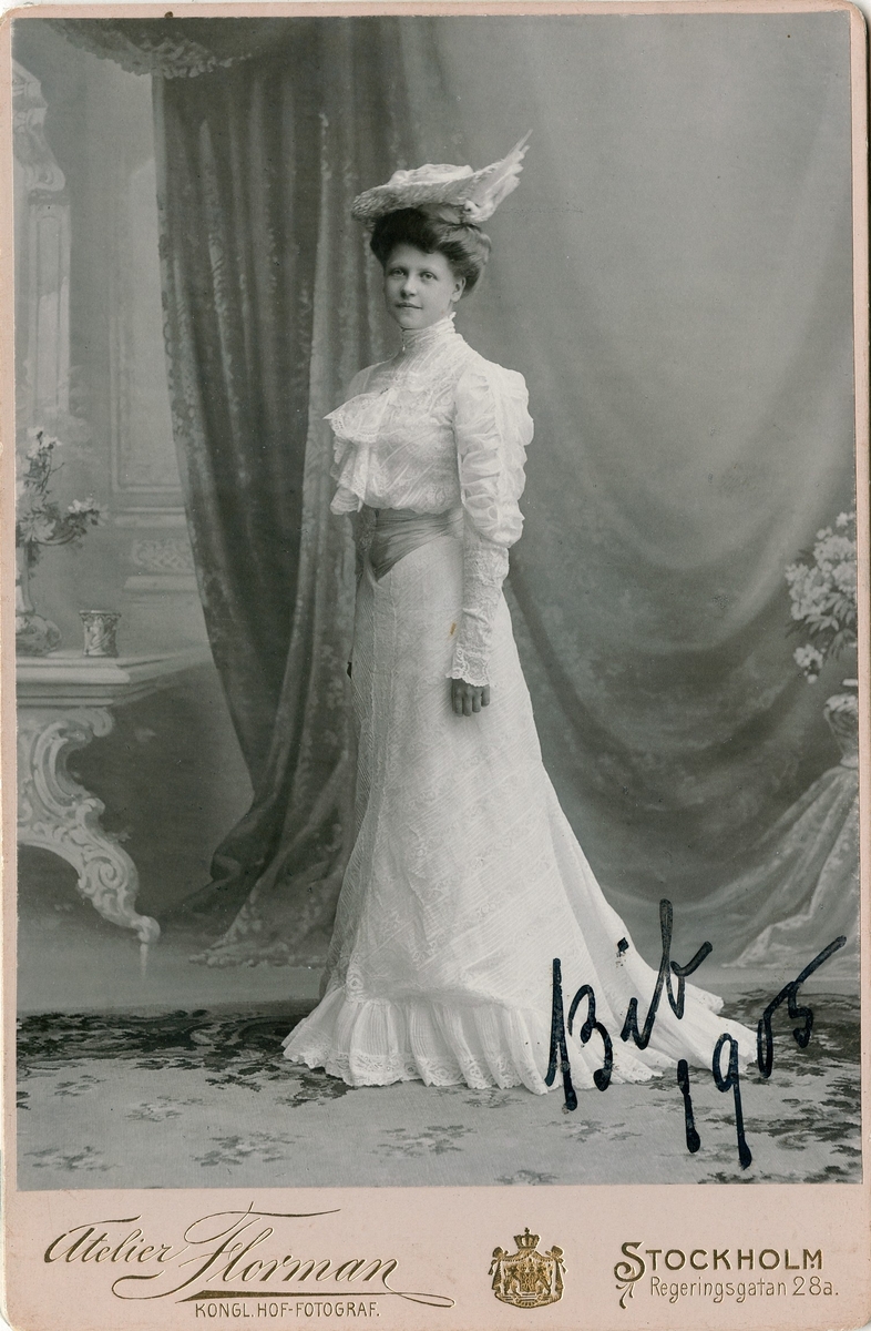 Bib Adelsköld fotograferad i vit klänning och vit hatt på Atelier ...