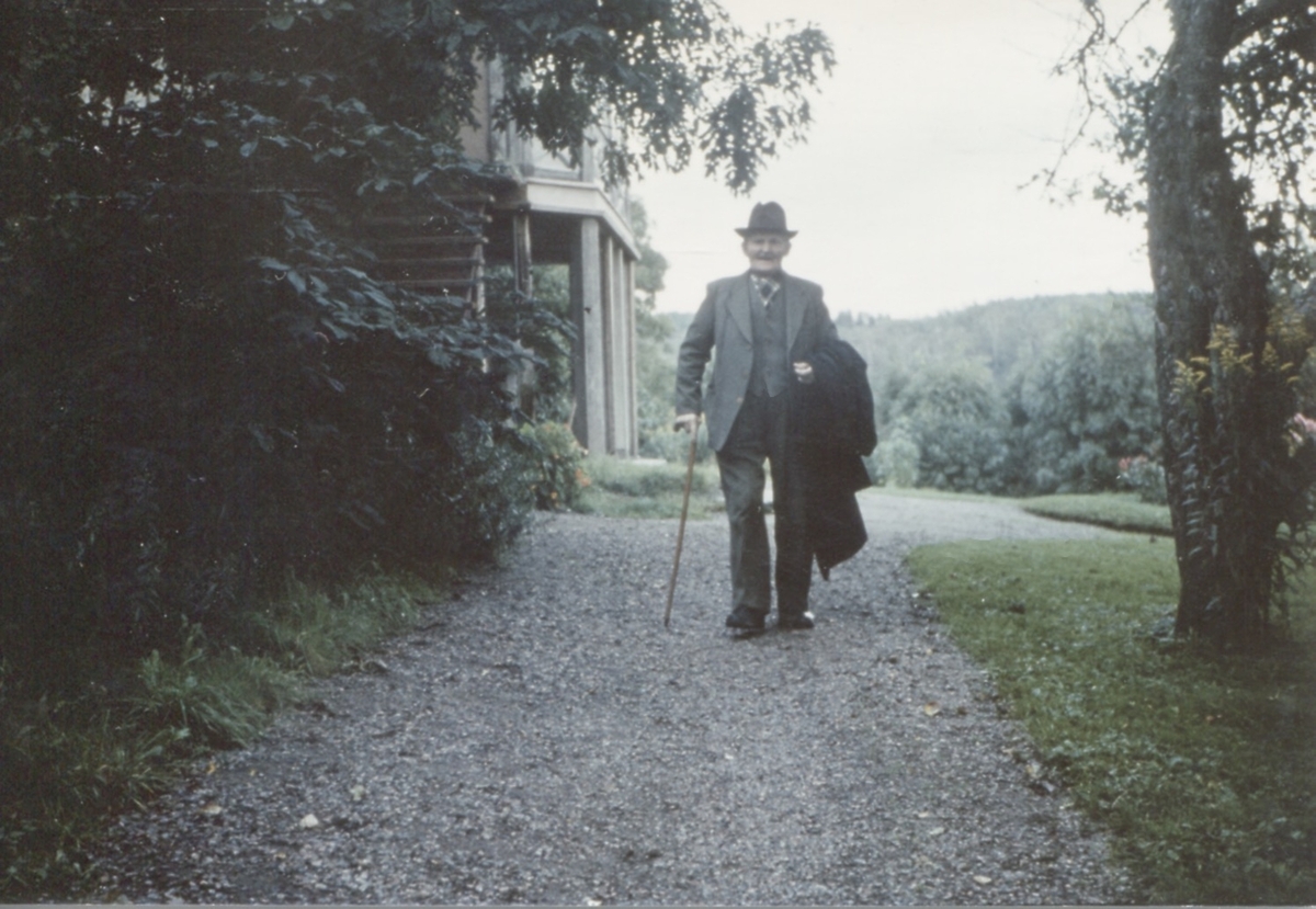 Robert Sandberg (1880-1961) spatserar med käpp på grusvägen utanför ...
