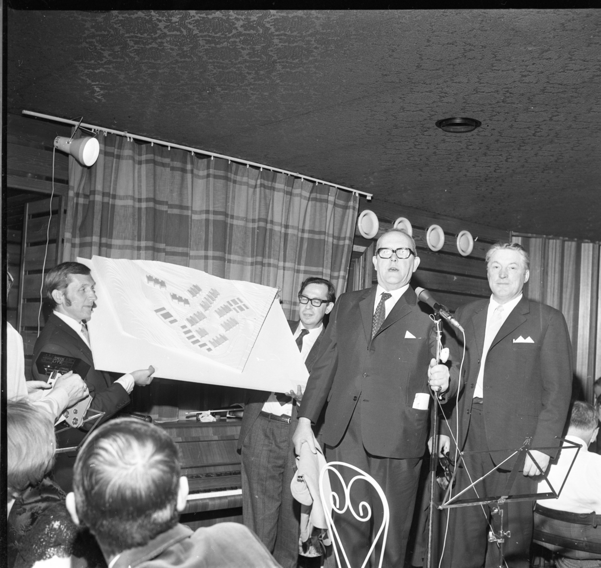 En modell av centrumbebyggelsen i Kaxholmen hålls upp av två män, en ...