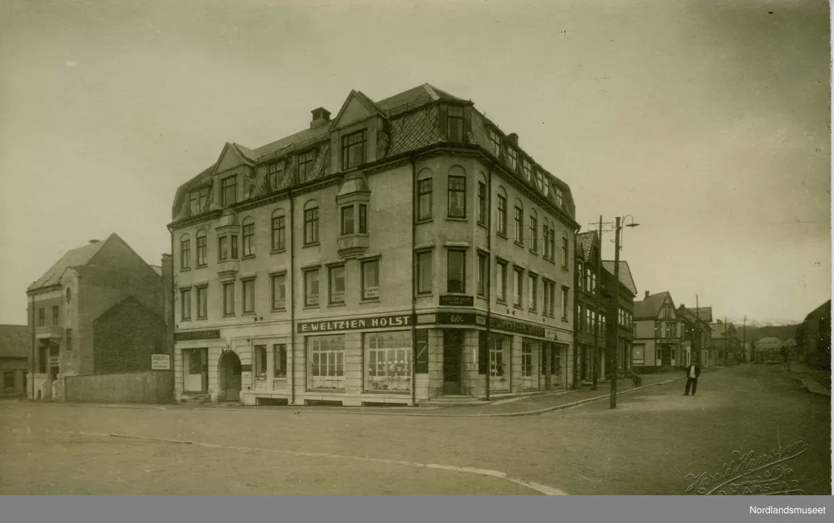 Postkort med bilde av forretningsbygning med skilt "E. Weltzen Holst ...