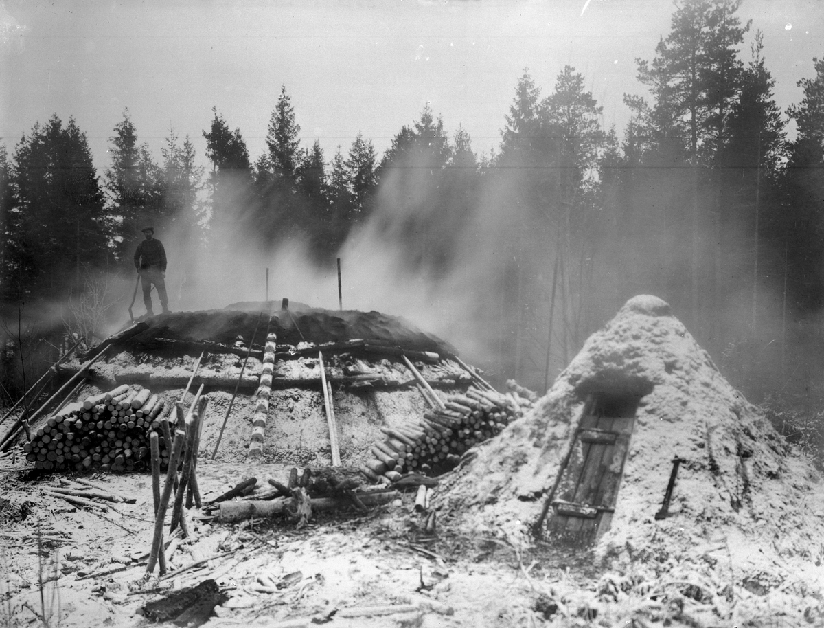 Kolmila och kolarkoja, en man med spade på kolmilan. Paul Selin ...