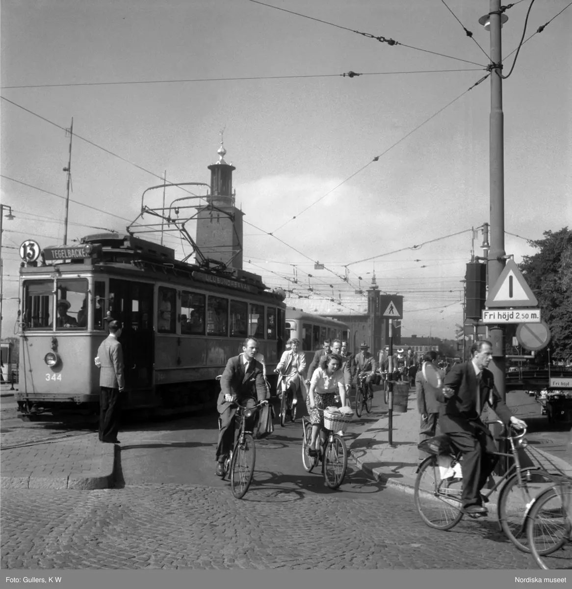 Tegelbacken, Stockholm. Cyklister och spårvagn, Stadshuset i bakgrunden ...