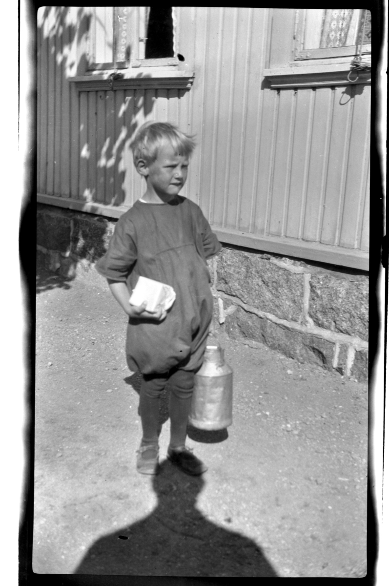 Julius Sundt står med et melkespann, ant Slagen. Fotografert 1923 ...