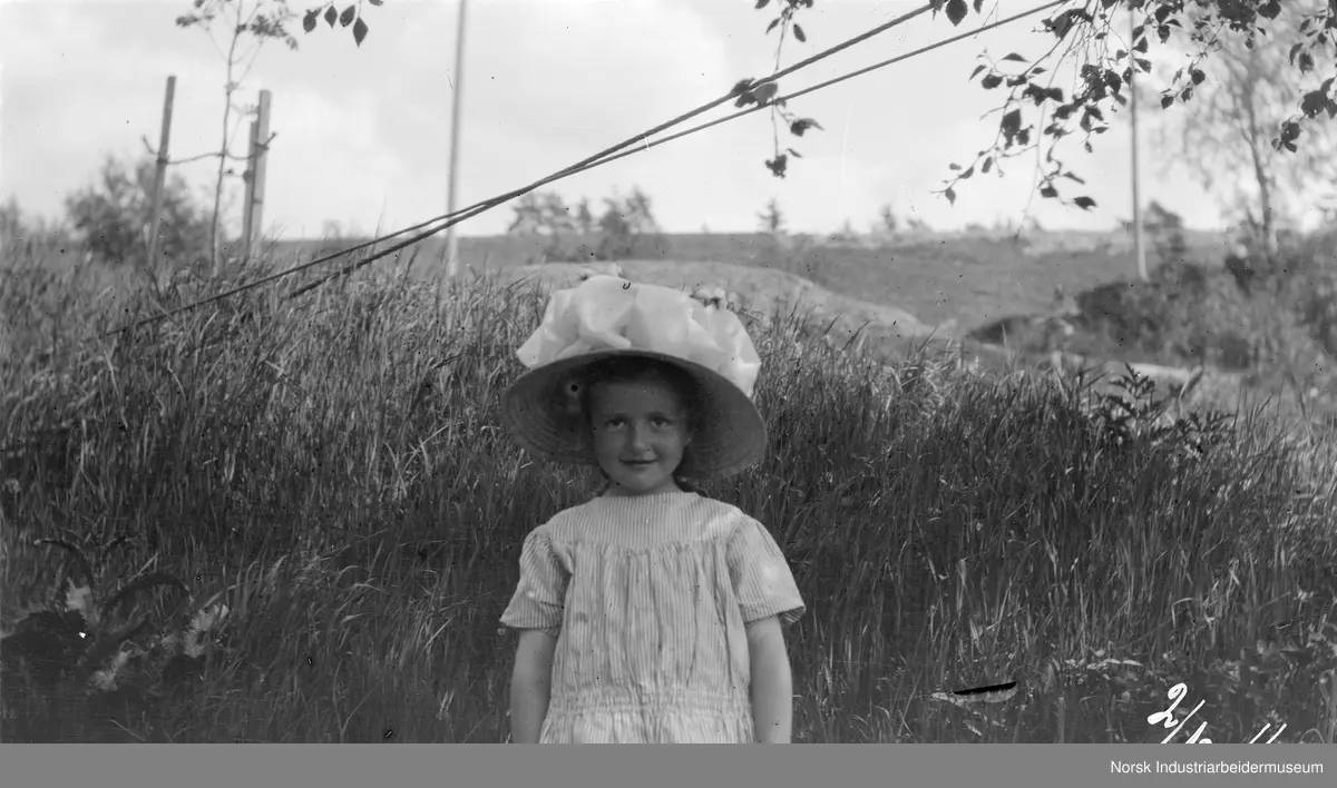 Jente med stor hatt oppstilt på jorde. - Norsk Industriarbeidermuseum ...