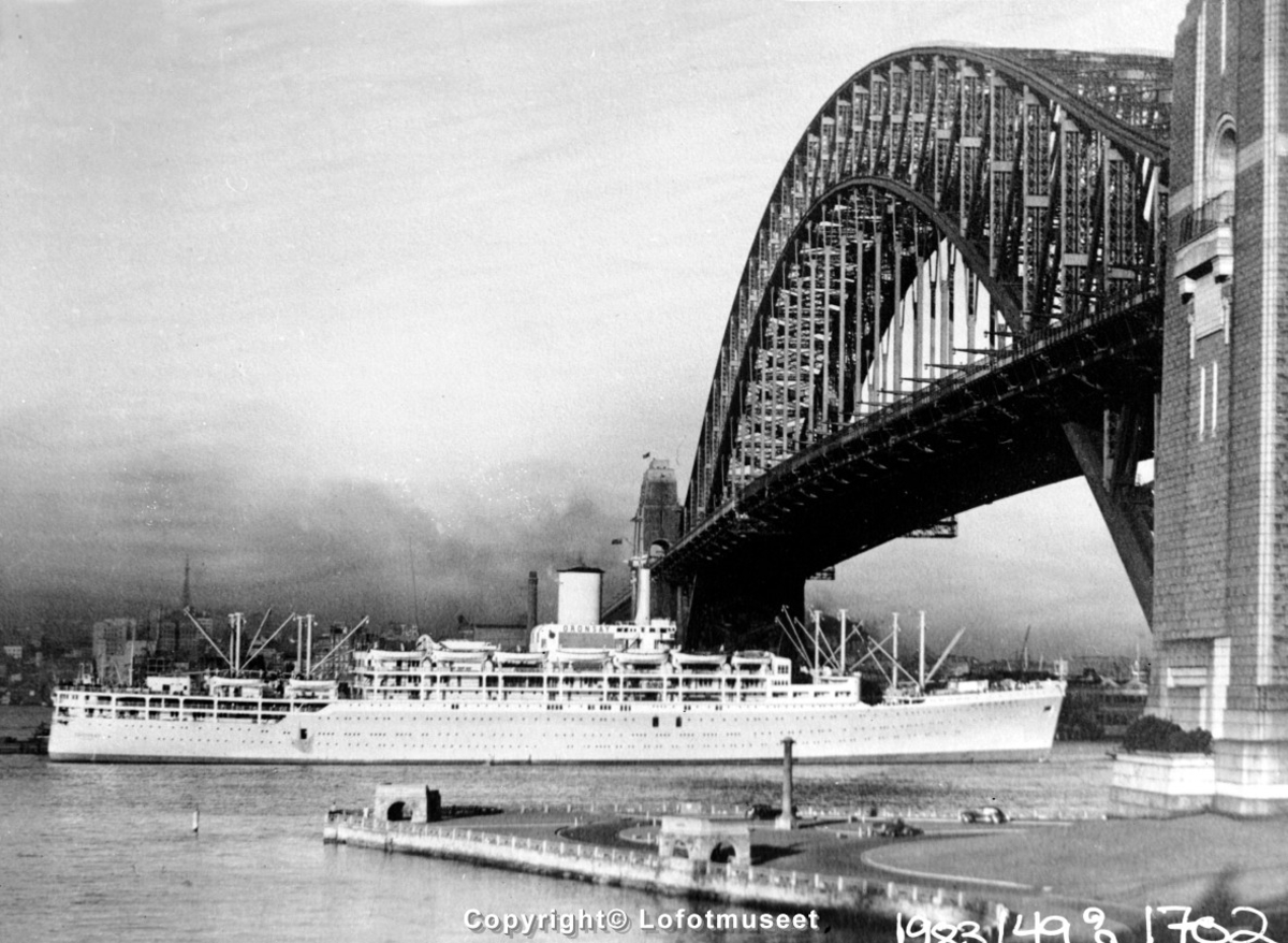 SS Oronsay passerer Sydney Harbour Bridge med Sydney sentrum i bakgrunn ...