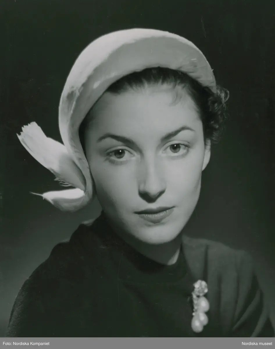 Porträtt av modell i vit hatt med fjäder, samt brosch. - Nordiska ...