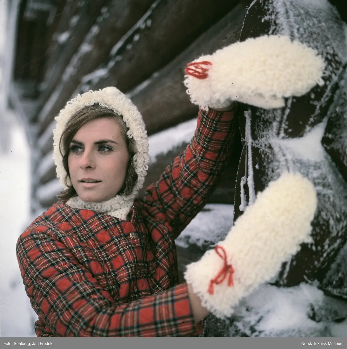 Kvinnelig modell viser vintermote. Hun har en hvit heklet genser med ...