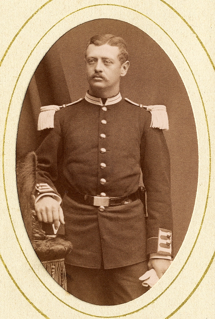 En man i militäruniform med epåletter. Han stöder ena handen på en käpi ...