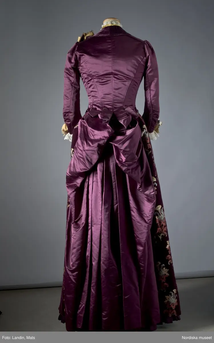 Klänning av mörklila atlassiden med slag av satin och isättning av gul ...