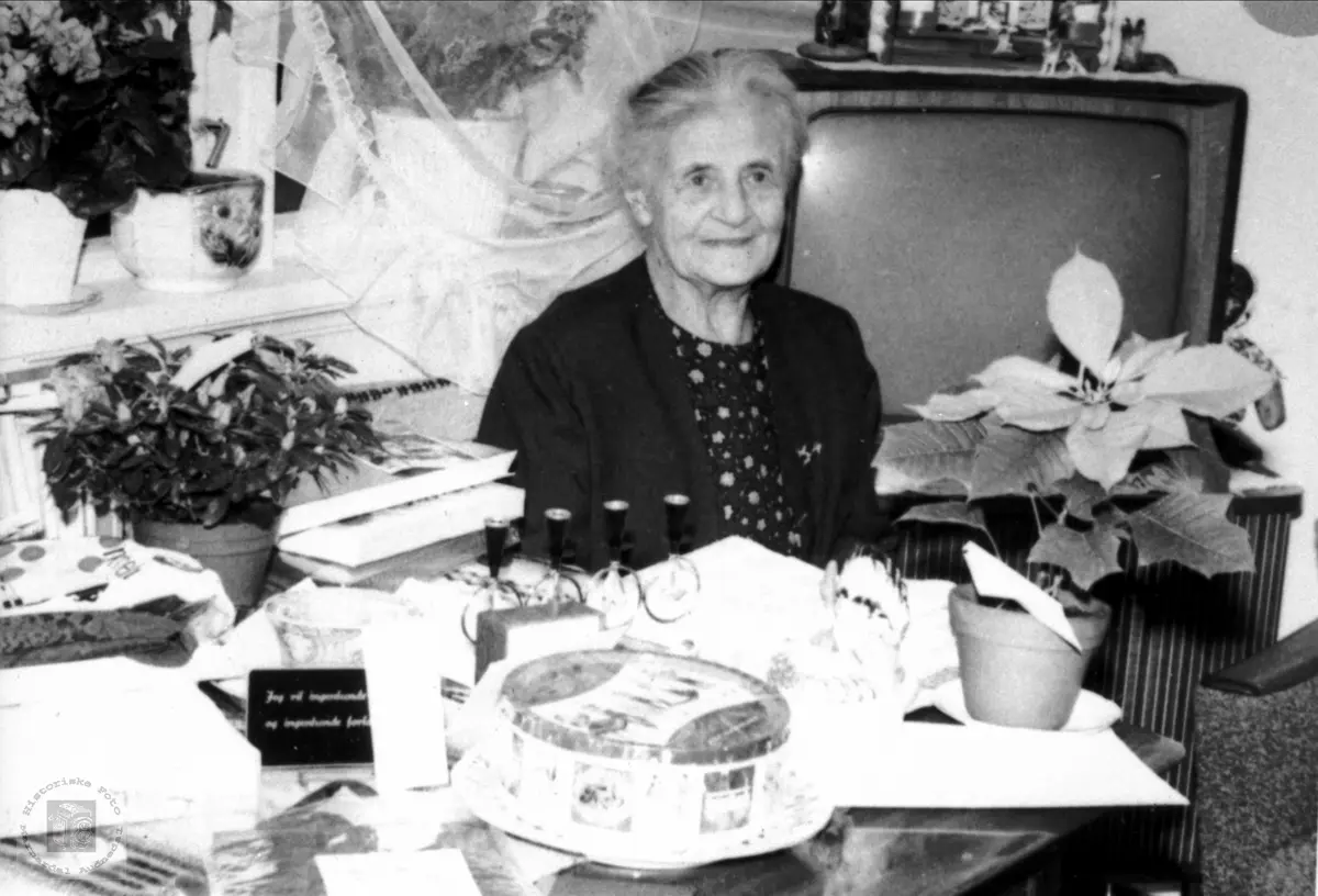 Portrett av 80 åringen Anna Haugland, Bjelland, blandt blomstene ...